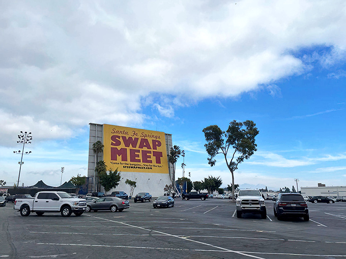 The massive yellow sign of the Santa Fe Springs Swap Meet shines like a beacon for bargain hunters. Beneath that California sky, every aisle hides a deal worth the dig.