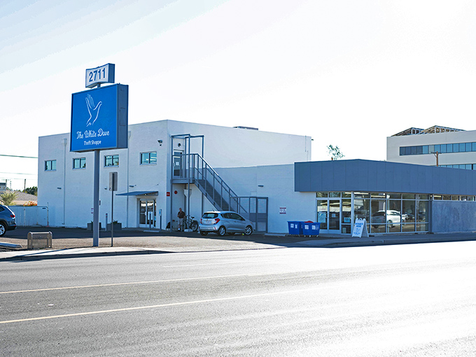 The White Dove Thrift Shoppe stands proudly against the Arizona sky, its blue sign promising treasures within. This unassuming building houses a bargain hunter's paradise.