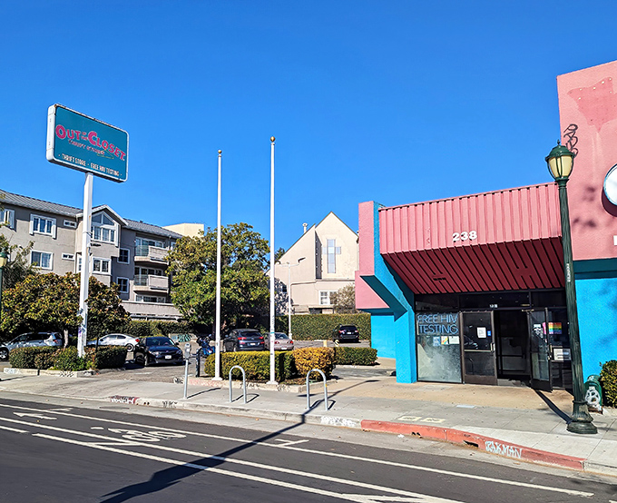 The pink and turquoise facade of Out of the Closet stands out like a fashionable flamingo in Oakland's urban landscape.