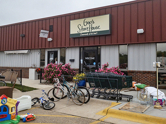 The unassuming exterior of God's Storehouse in Topeka belies the treasure trove within. Those pink flowers aren't just decoration—they're nature's way of saying "bargains blooming inside!"
