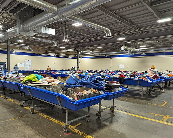 The heart of the operation: massive blue bins filled with potential treasures. Archaeologists have digs, thrift enthusiasts have these industrial-sized containers of possibility.