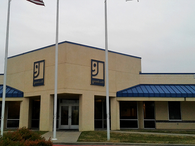 The iconic smiling Goodwill logo welcomes bargain hunters like a beacon of thrifty hope. This unassuming exterior hides a treasure trove within.