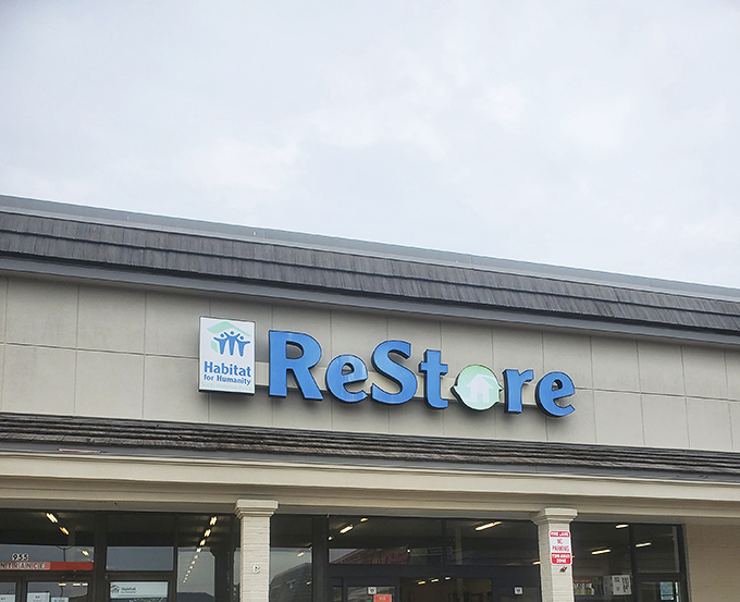 The iconic blue ReStore sign beckons bargain hunters like a lighthouse guiding ships to treasure-filled shores.