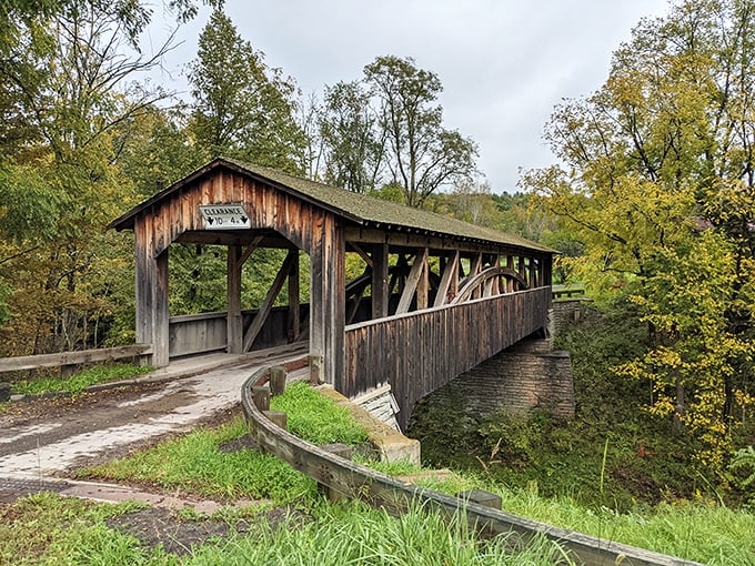 Knapp's Covered Bridge stands like a wooden sentinel among autumn foliage, its weathered planks telling stories of countless crossings through the centuries.