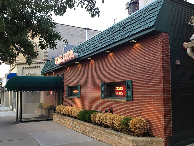 The iconic Pine Club exterior stands proudly on Brown Street, its vintage neon sign promising carnivorous delights that have kept Daytonians coming back since 1947.