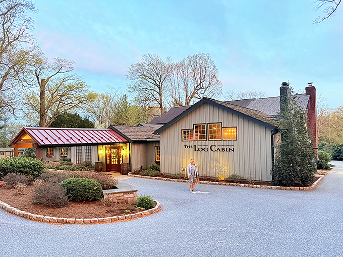 The Log Cabin's exterior glows with warm invitation at dusk, like a storybook cottage that happens to serve world-class steaks instead of gingerbread.
