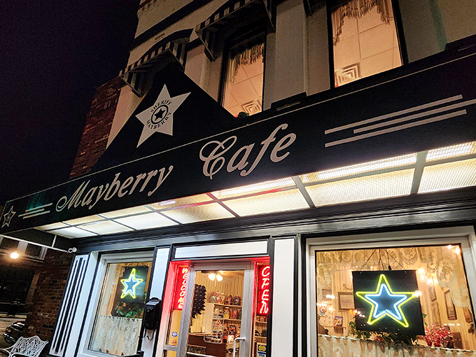 The iconic black awning with sheriff's stars beckons like a time machine to simpler days. Mayberry Cafe's storefront glows with nostalgic charm after sunset.