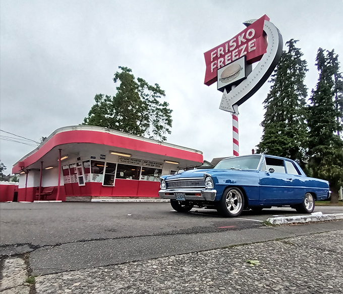 The iconic red and white Frisko Freeze, framed by a vintage car out front, stands like a time machine to the 1950s, beckoning hungry Tacoma residents with its retro charm.