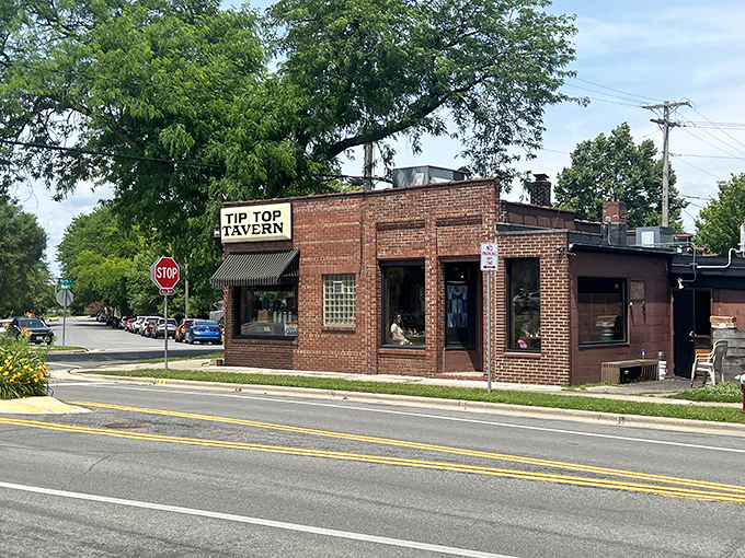 The unassuming brick exterior of Tip Top Tavern stands like a culinary sentinel on the corner, its yellow sign promising delights that fancy restaurants often miss.