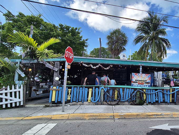 The blue fence and stop sign aren't keeping anyone away from this tropical seafood sanctuary. Key West's culinary treasure hides in plain sight.