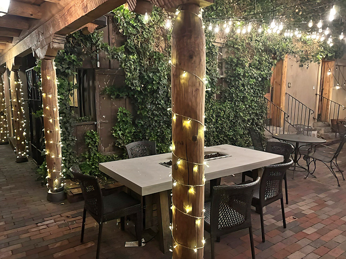 A magical evening awaits under twinkling lights and ivy-covered walls. This enchanted patio setting transforms ordinary dinners into memorable Santa Fe nights.