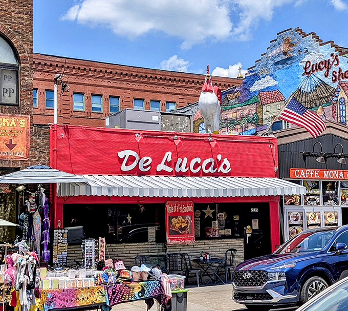 The iconic red facade of DeLuca's with its rooftop chicken statue stands out in Pittsburgh's Strip District like a breakfast lighthouse guiding hungry souls home.