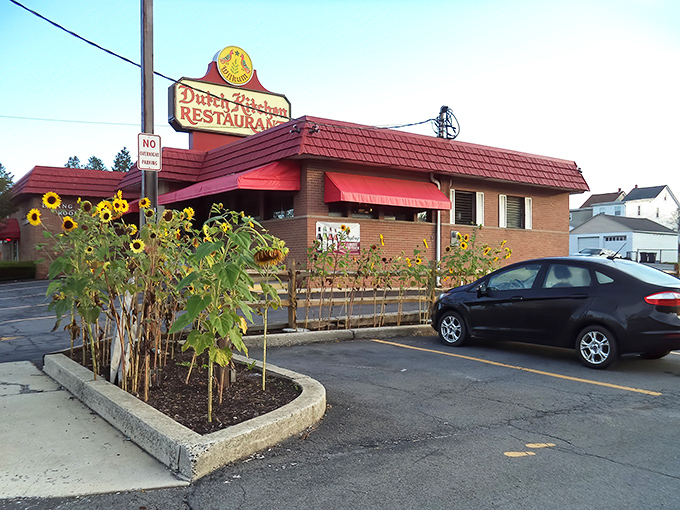 The iconic red roof and vintage sign of Dutch Kitchen welcomes hungry travelers, with cheerful sunflowers nodding in agreement about that legendary meatloaf.