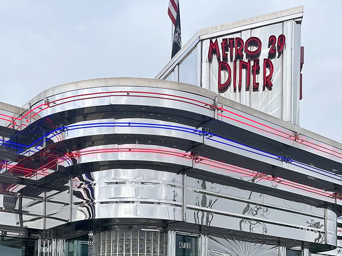 That gleaming Art Deco exterior isn't just eye candy—it's a time machine disguised as a diner, complete with patriotic neon trim.