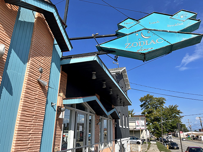 The iconic turquoise diamond sign of Zodiac Dinor beckons breakfast enthusiasts like a celestial lighthouse guiding hungry ships to harbor.