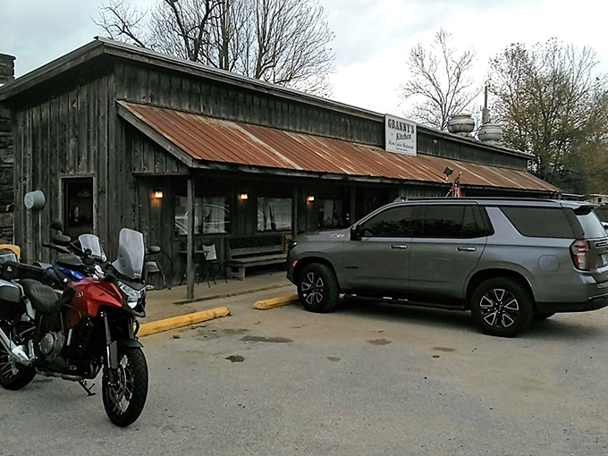 The rustic charm of Granny's Kitchen beckons from the roadside, its weathered tin roof and wooden facade promising authentic Arkansas comfort food within. 