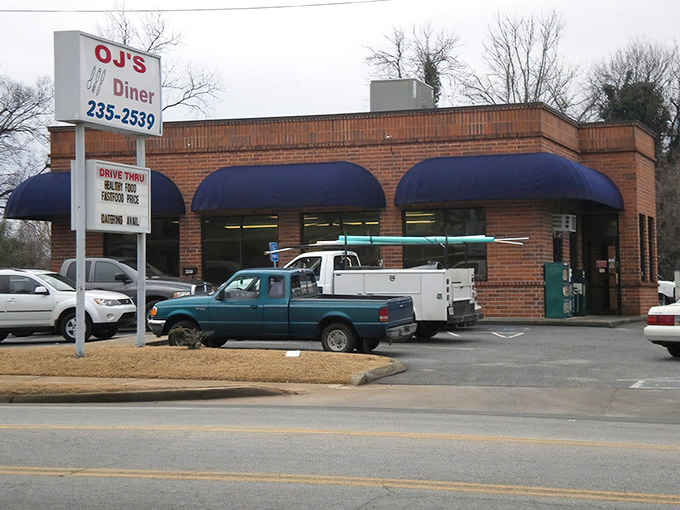 The unassuming brick exterior of OJ's Diner proves once again that culinary treasures often hide in plain sight, those blue awnings beckoning hungry travelers like a Southern lighthouse.