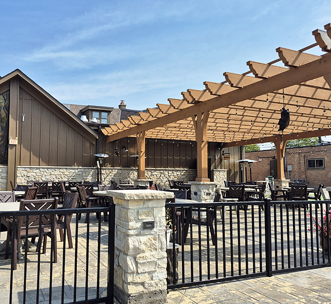 The outdoor patio at Bill's Pizza & Pub offers a rustic retreat with its wooden pergola and stone accents—northwoods charm in suburban Mundelein.