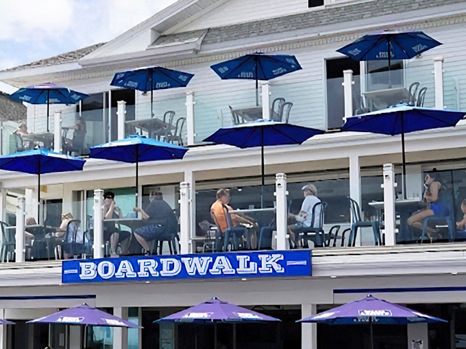The iconic blue-and-white facade of Boardwalk Cafe & Pub stands proudly along Hampton Beach, those blue umbrellas practically waving you in like old friends.