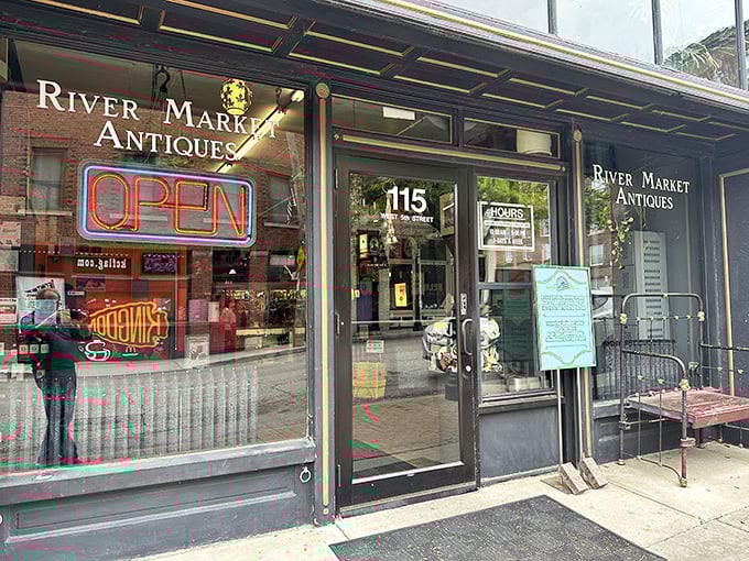 The iconic storefront of River Market Antiques beckons with its glowing neon "OPEN" sign &ndash; a portal to treasures waiting to be discovered inside this Kansas City landmark.