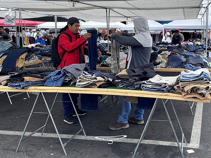 Denim paradise! Shoppers examine stacks of jeans that could clothe a small nation, proving one person's castoffs become another's fashion statement.