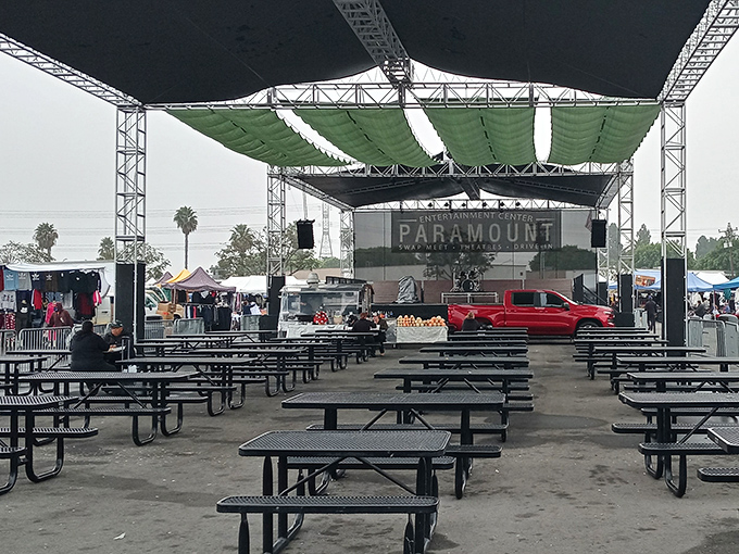The entertainment center at Paramount Swap Meet offers a shaded respite when your shopping legs need a break. California palm trees complete the backdrop.