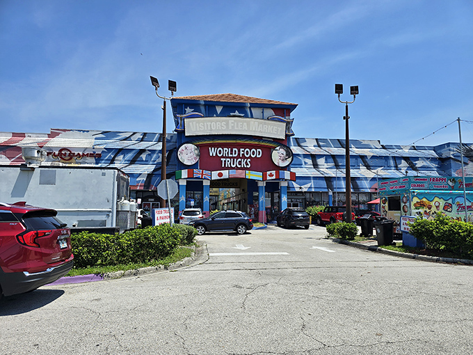 The blue-and-white facade of Visitors Flea Market stands like a portal to bargain paradise, promising treasures and treats behind its colorful entrance.
