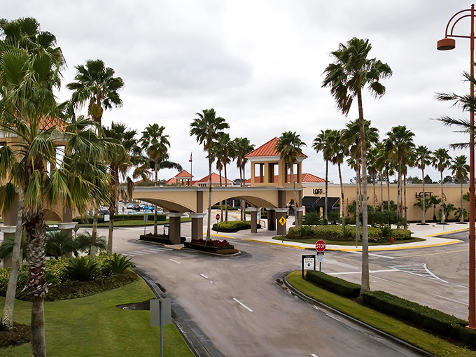 Palm trees stand sentinel at the entrance to Vero Beach Outlets, where Florida sunshine meets retail therapy in Mediterranean-inspired architecture.