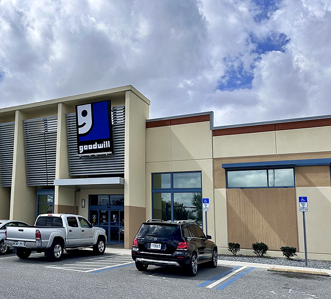 The smiling Goodwill logo welcomes bargain hunters like a beacon of hope for both wallets and wardrobes. Modern architecture meets thrifty treasures.