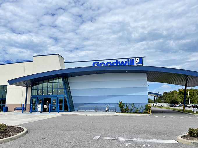 The blue-trimmed facade of Goodwill's 34th Street Superstore stands like a beacon of bargain hope under Florida's endless sky.