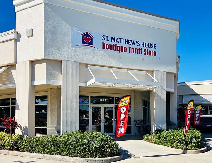 Like a well-dressed ambassador of second chances, this bright storefront welcomes bargain hunters with cheerful "OPEN" flags fluttering in the Florida breeze.