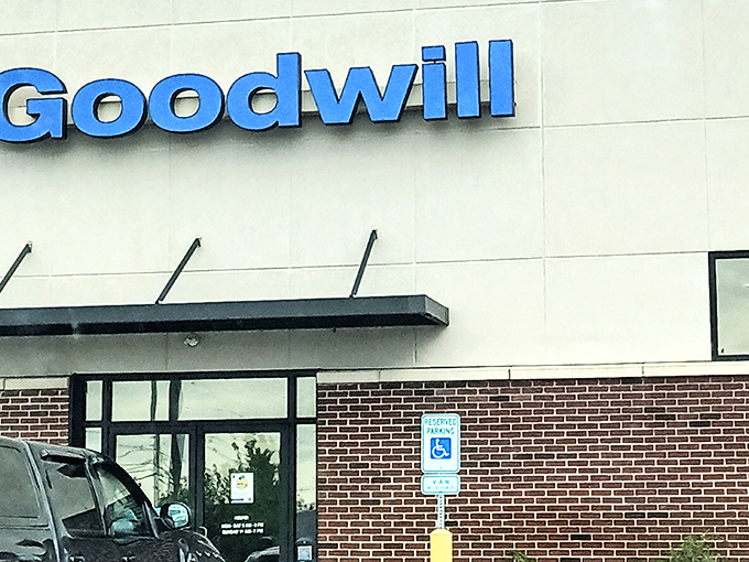 The iconic blue Goodwill sign beckons like a beacon of bargain possibilities against the brick-and-concrete building. Treasure hunting starts here!