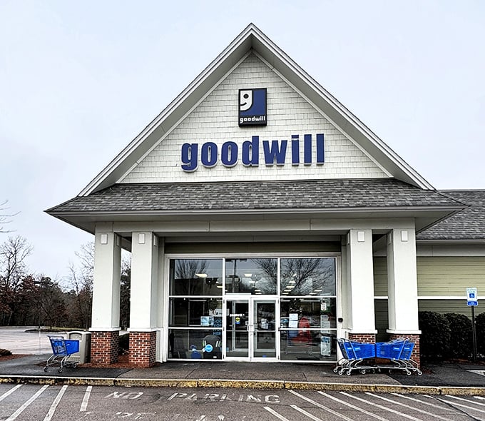 The iconic blue Goodwill sign welcomes bargain hunters like a beacon of thrifty hope against the New Hampshire sky.
