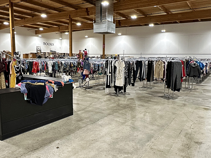 The vast warehouse interior stretches endlessly, where clothing racks stand like soldiers ready for your inspection mission.