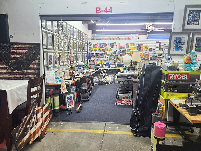 Booth B-44 showcases the beautiful chaos of collecting – patriotic memorabilia, power tools, and framed artwork creating a time capsule of American nostalgia that would make Marie Kondo faint.