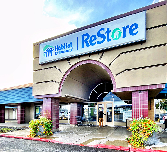 Welcome to bargain paradise! The Habitat for Humanity ReStore stands proud against the Alaskan sky, a beacon of hope for thrifty shoppers and DIY dreamers alike.