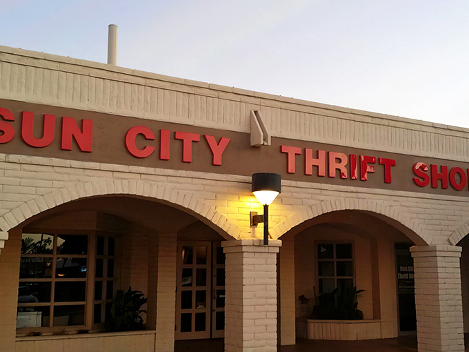 The iconic Sun City Thrift Shop facade glows in the Arizona sunshine, promising treasure hunters a day of discovery behind those unassuming doors.