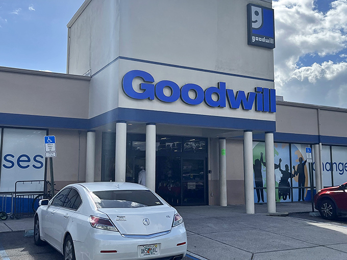 The blue Goodwill sign beckons like a lighthouse for bargain hunters, promising treasures inside this unassuming Tampa building.