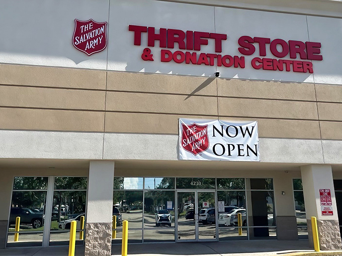 The Salvation Army Thrift Store stands proudly under Florida's blue skies, a beacon for bargain hunters with its unmistakable red signage and promise of treasures within.