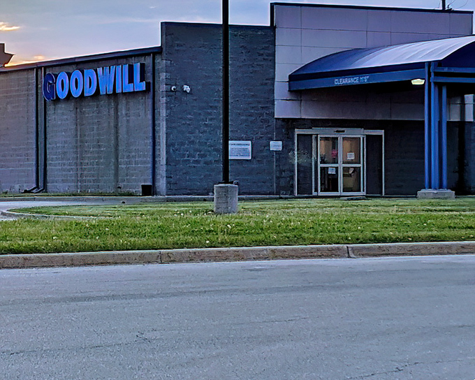 The blue Goodwill sign glows like a beacon of bargain hope against the twilight sky. Treasure hunters, your mothership awaits.