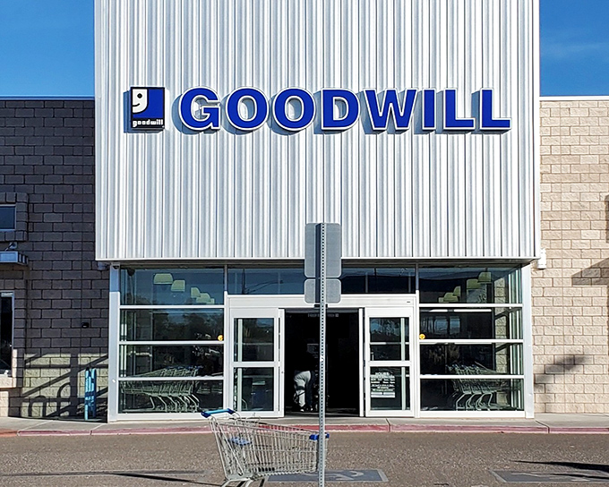 The iconic blue Goodwill sign beckons bargain hunters like a retail oasis in the desert of full-price shopping. Treasure awaits inside!