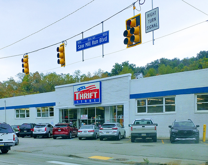 The patriotic facade of Red White & Blue Thrift Store stands proudly on Saw Mill Run Boulevard, a beacon of bargain-hunting glory beneath Pittsburgh's traffic lights.