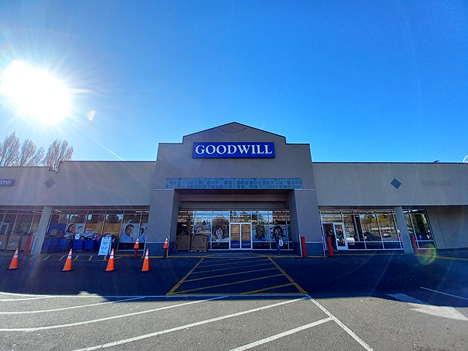 The blue Goodwill sign beckons like a lighthouse to bargain hunters. Under clear Washington skies, this unassuming exterior houses countless treasures waiting to be discovered.