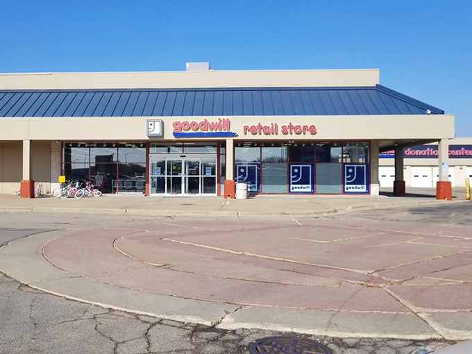 The iconic blue and red Goodwill sign beckons like a lighthouse for bargain hunters navigating the sea of retail inflation.