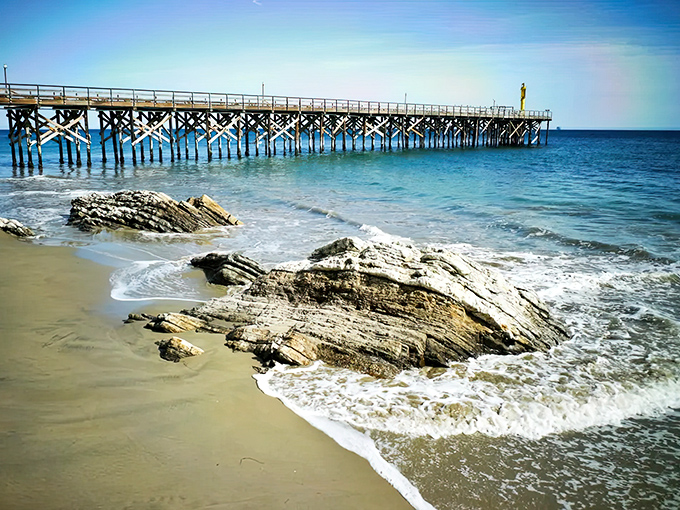 The wooden pier stretches toward the horizon like a pathway to paradise, while rocky outcroppings create nature's perfect tidepooling playground.