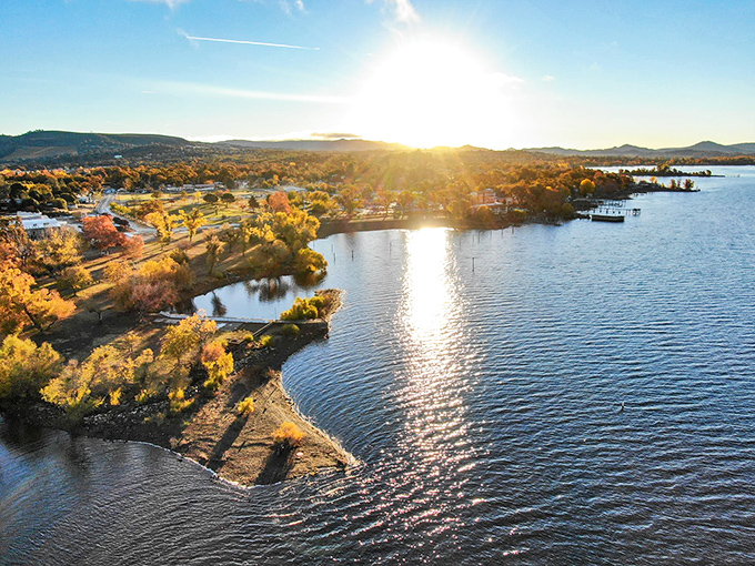 Sunset paints the lake in liquid gold, while autumn trees stand like nature's honor guard. This is what affordable paradise looks like.