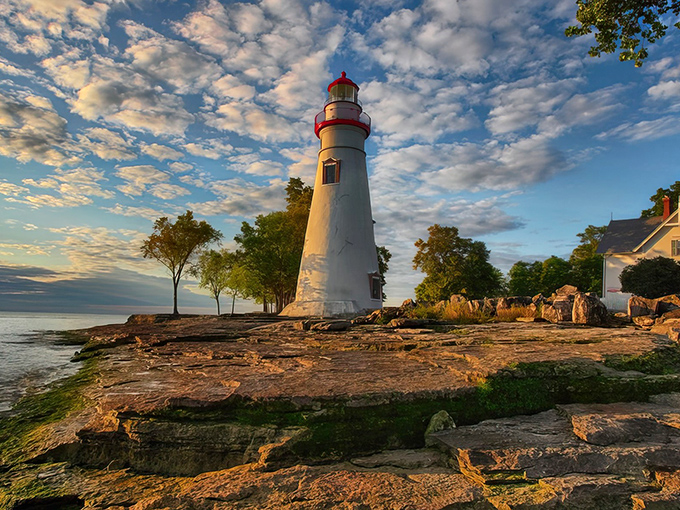 Morning light bathes the limestone tower in golden hues while Lake Erie stretches endlessly beyond, a scene worth setting your alarm for.