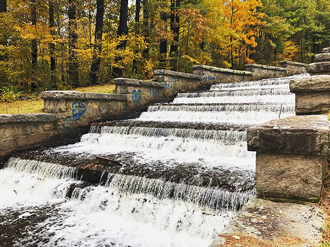 The stone spillway at Ashland State Park creates nature's perfect staircase, where water tumbles down in hypnotic rhythm against a backdrop of autumn glory.