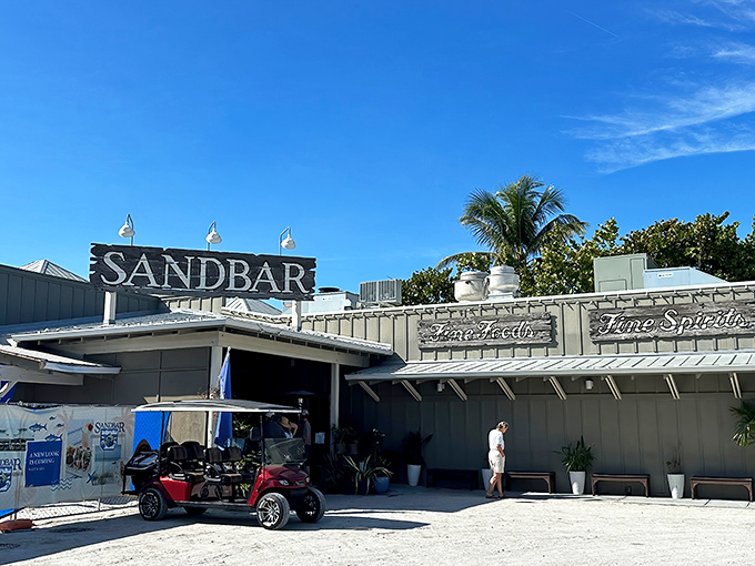 Daytime reveals The Sandbar's casual coastal charm, where golf carts park alongside dreams of perfect grouper sandwiches.