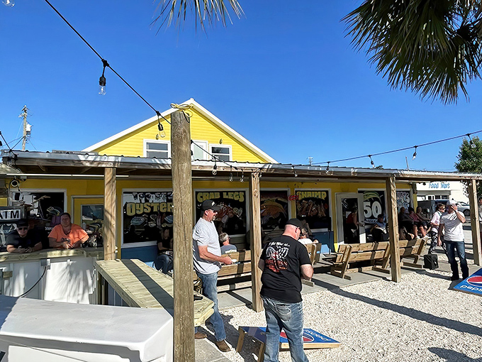 Florida sunshine bathes the yellow clapboard exterior where locals gather, proving the best seafood spots rarely need fancy architecture to draw crowds.